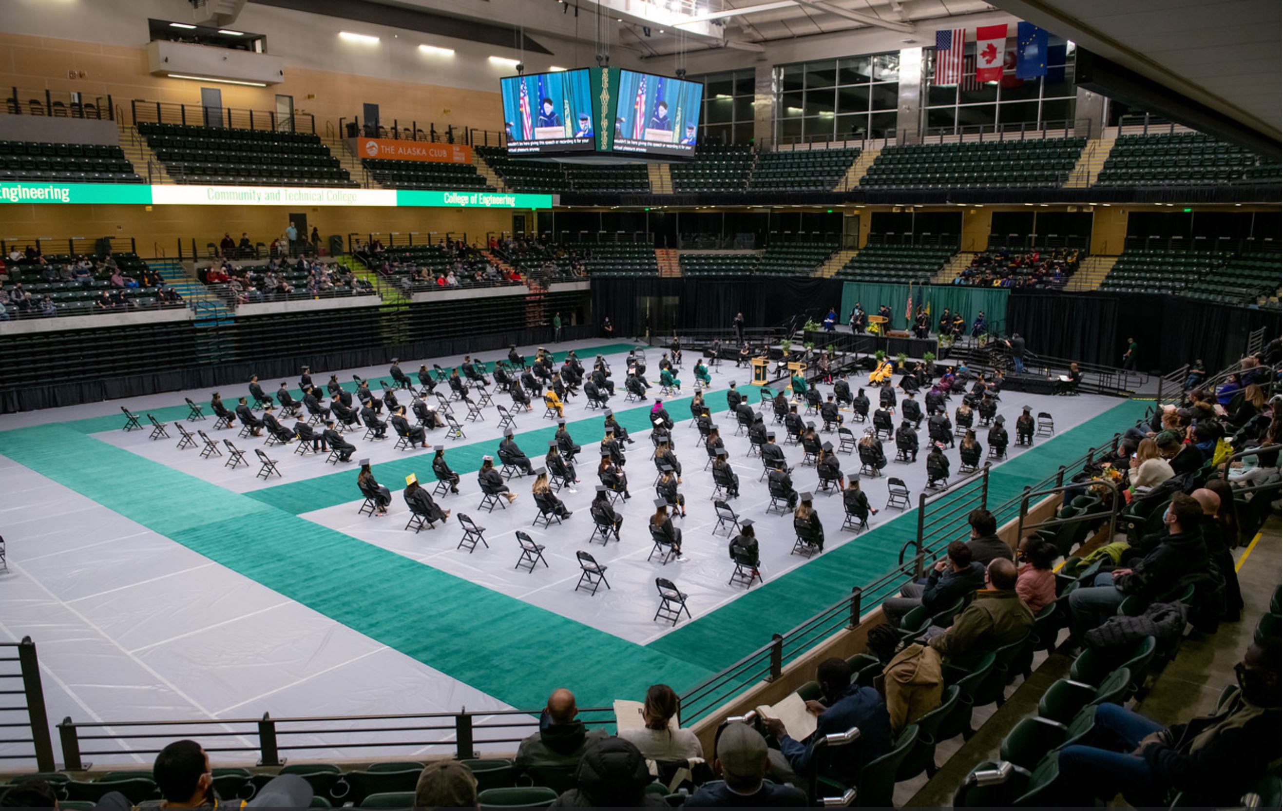 Down printer holds up diplomas for UAA grads
